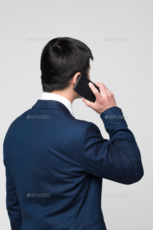 Rear view of businessman in a suit talking on the phone. Stock Photo by ...