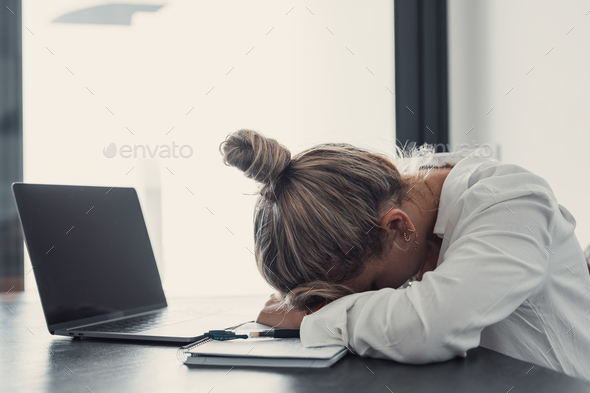 Exhausted young Caucasian female employee sleep desk at office overwork ...