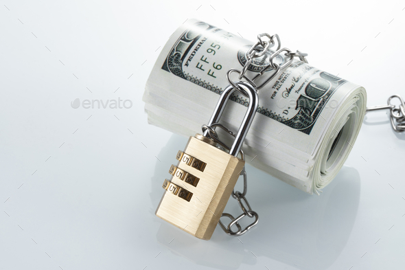 High angle shot of a stack of dollar bills chained and locked with a ...