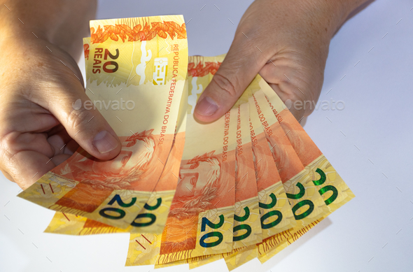 Male hand holding 20 Reais banknotes on white background Stock Photo by ...