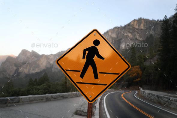 Pedestrian traffic sign with mountains in the background Stock Photo by ...
