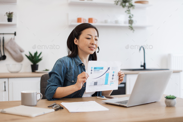 Employee discussing data via graphs on video call at home Stock Photo ...