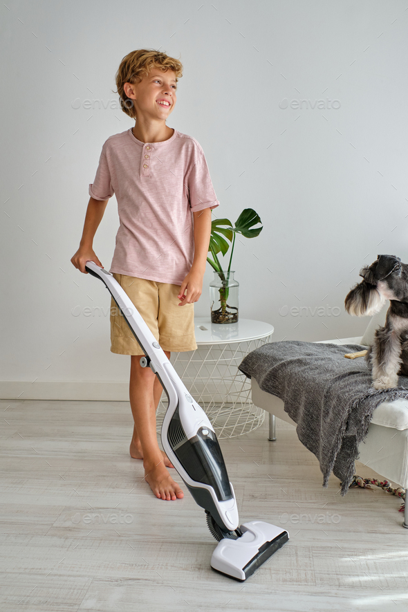 Glad boy cleaning living room floor Stock Photo by ADDICTIVE_STOCK