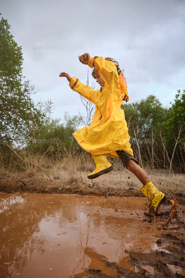 Preteen boy jumping over puddle Stock Photo by ADDICTIVE_STOCK | PhotoDune