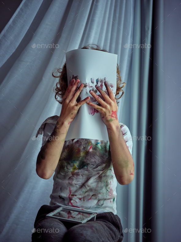 Little artist hiding behind paper sheet Stock Photo by ADDICTIVE_STOCK