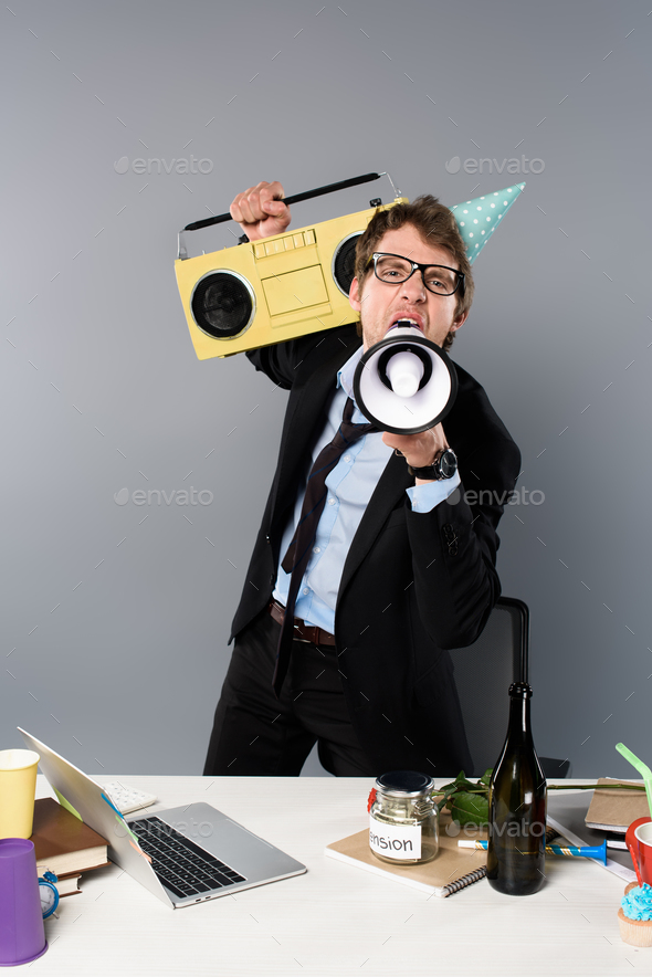drunk businessman at workplace in party cap with vintage tape recorder ...