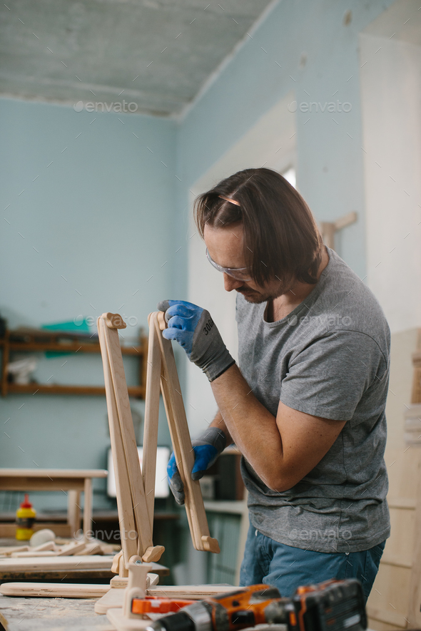 A carpenter makes wooden toys in a carpentry workshop. Making a bed ...