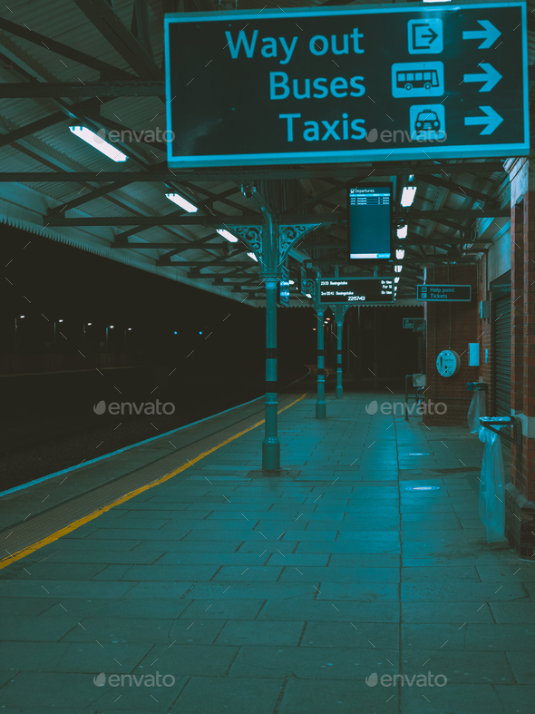 Vertical shot of a sign for guides inside a station awith light at ...