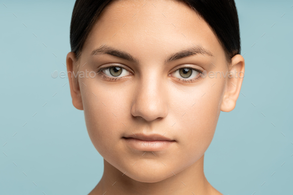Portrait of brunette calm teenage girl with slight smile on face ...
