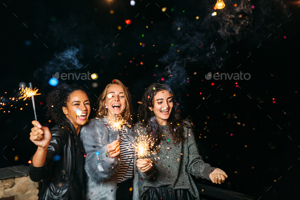 Three happy women having fun with sparklers. Outdoor party. Stock Photo ...