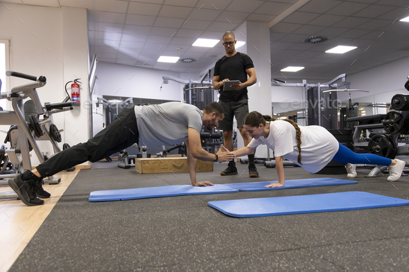 Two people doing push-ups and clapping hands on a gym Stock Photo by ...