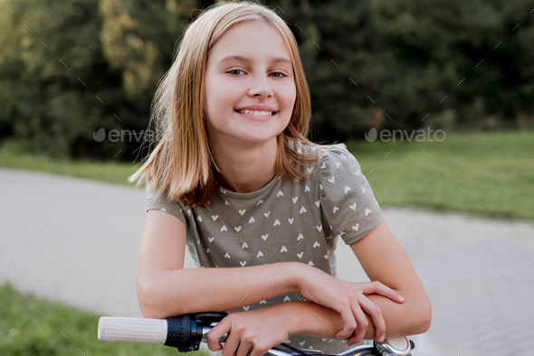 Cute preteen girl with bycicle outdoors Stock Photo by tan4ikk | PhotoDune