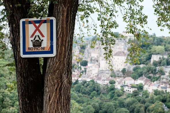 No picnic sign on a tree with Rocamadour village in the background ...