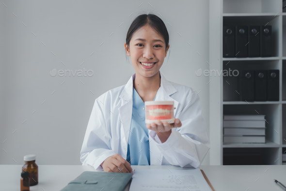 Female dentist with dentures for explaining teeth, recommending ...