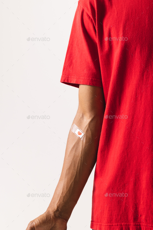 Midsection of biracial man with heart sticking plaster on arm, on white ...