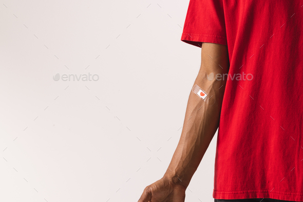 Midsection of biracial man with heart sticking plaster on arm, on white ...