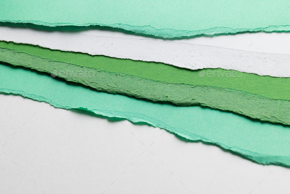 Ripped up pieces of coloured paper and copy space on white background ...