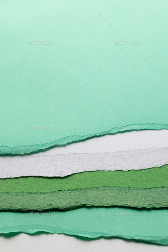 Ripped up pieces of coloured paper and copy space on white background ...