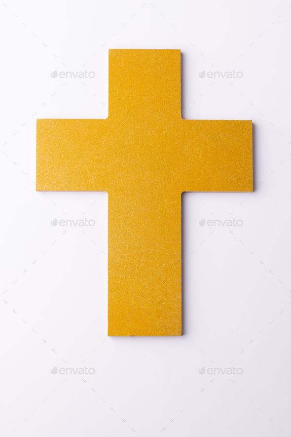 Overhead vertical image of yellow christian cross, on white background ...