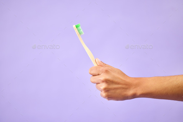 Dental, teeth whitening and hand with toothbrush in studio for oral ...