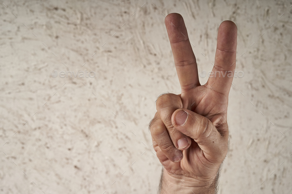 man's hand making a V with two of his fingers Stock Photo by wirestock