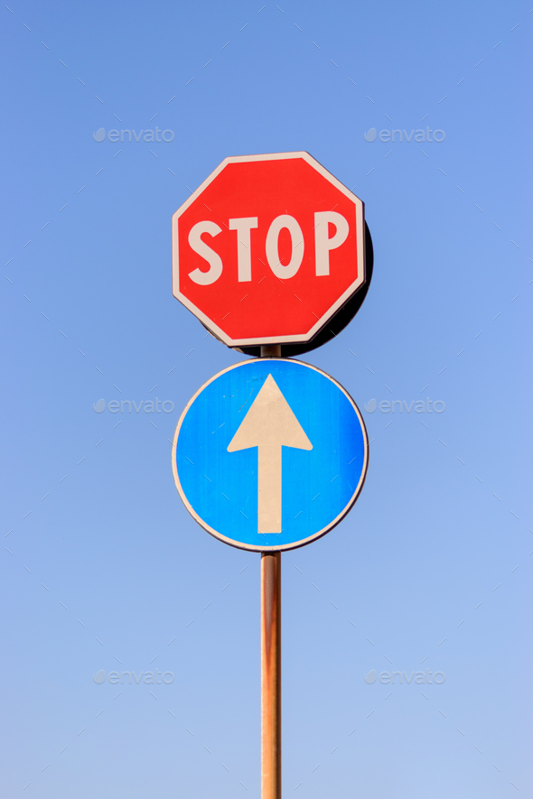 Vertical shot of a pillar with a stop sign on a cloudless day in Genoa ...