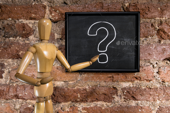 Wooden mannequin showing a question mark on chalkboard, blackboard over ...