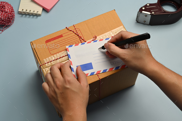 Above view of man signing greeting card, surrounded by gift wrapping ...