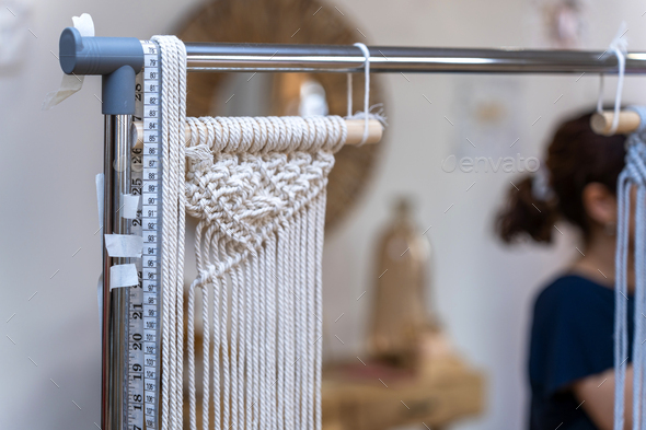 White macrame frame with tape measure hanging Stock Photo by solerfotostock