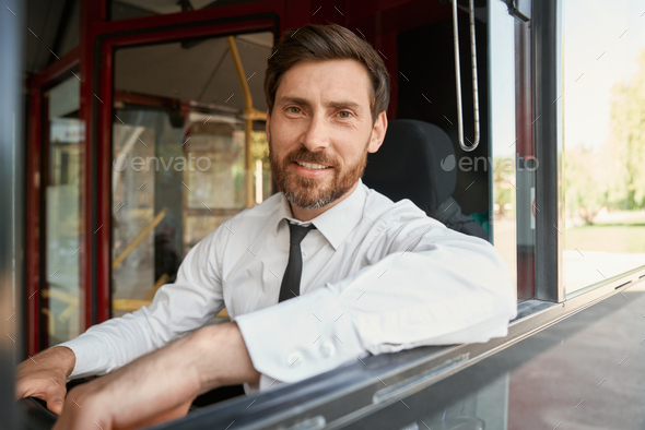 Confident bus driver posing with one arm resting on open window. Stock ...