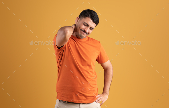 Sad brazilian man in t-shirt pressing his hand to neck and suffering ...