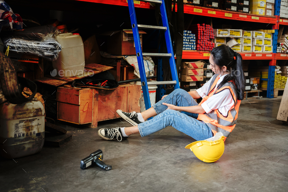 A female warehouse worker has an accident from falling from a height ...