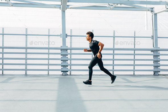 Side view of athlete sprinting in pedestrian tunnel. Male runner ...