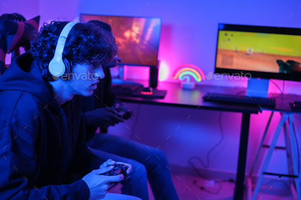 Two young people playing video games from the room prepared to play ...