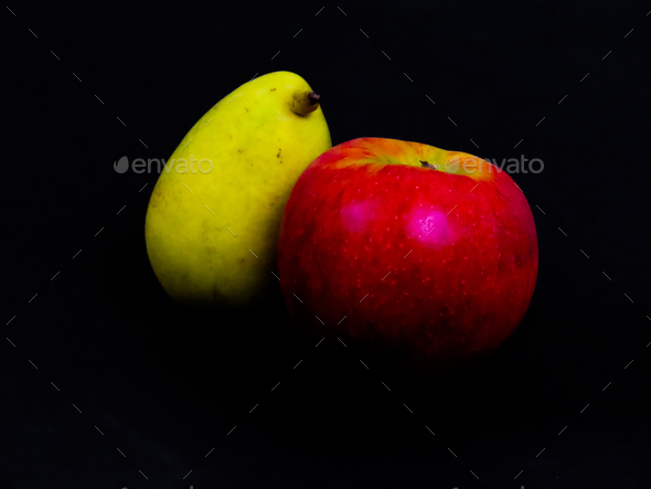 Red apple and mango isolated in the black background, the concept of ...