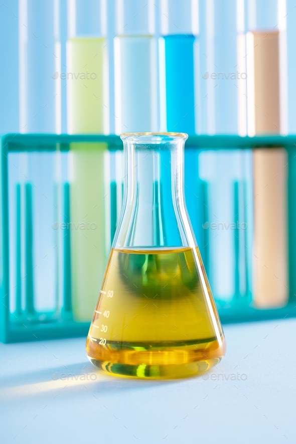 Vertical closeup shot of Erlenmeyer flask with yellow liquid and test ...
