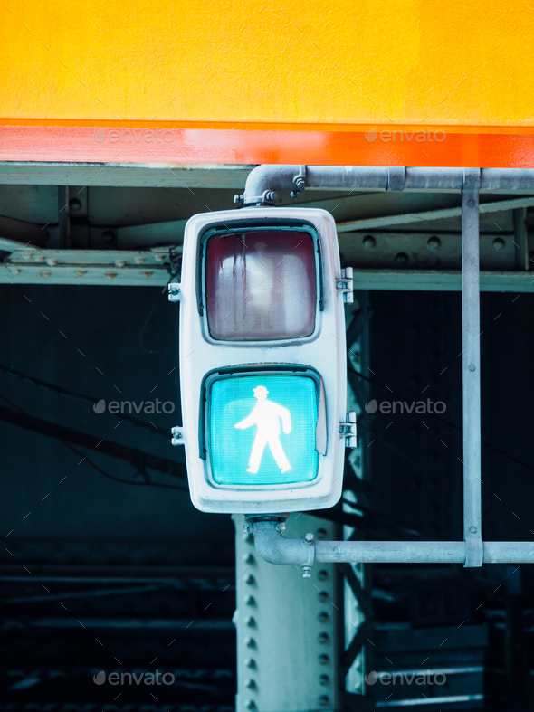 Vertical shot of an electric pedestrian crosswalk sign with green light ...