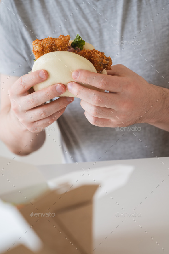 Vertical banner with man eating bao bun. Traditional asian street food ...