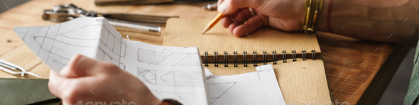 White craftsman drawing while working with leather in workshop Stock ...