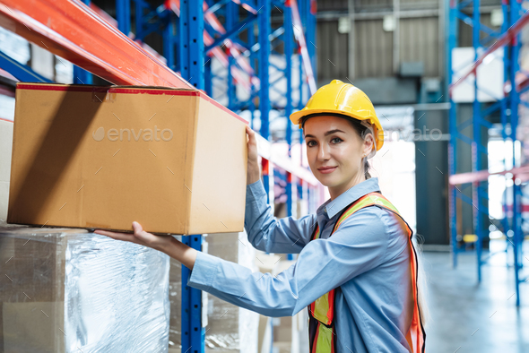 Warehouse female worker holding box package and moving boxes on the ...