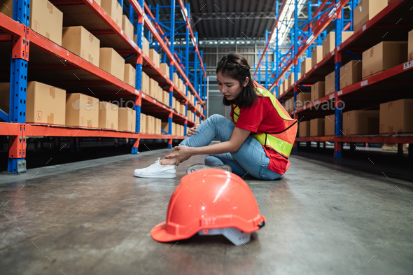 A female warehouse worker has an accident from falling from a height ...