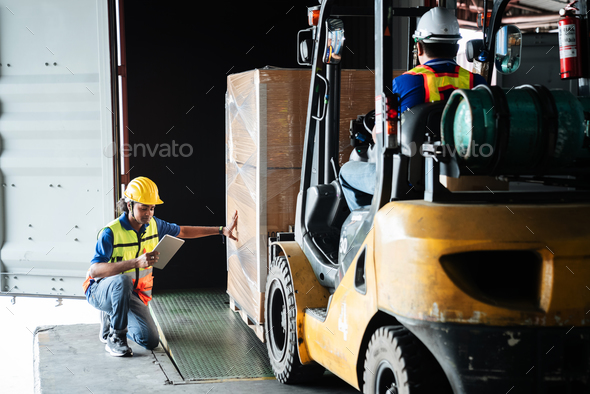 Warehouse worker workers with forklift in a warehouse. Use forklift ...