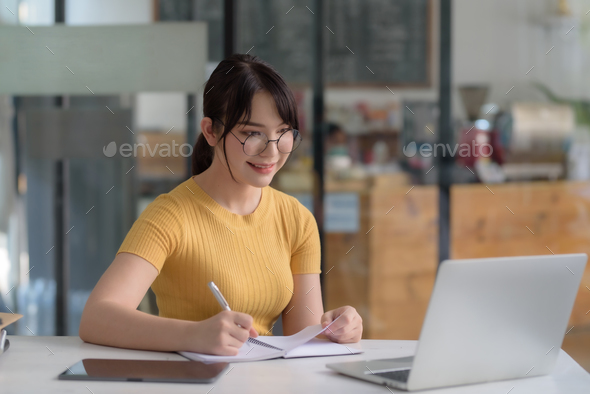 Young Asian Woman Studying with Laptop and Taking Notes for Online ...