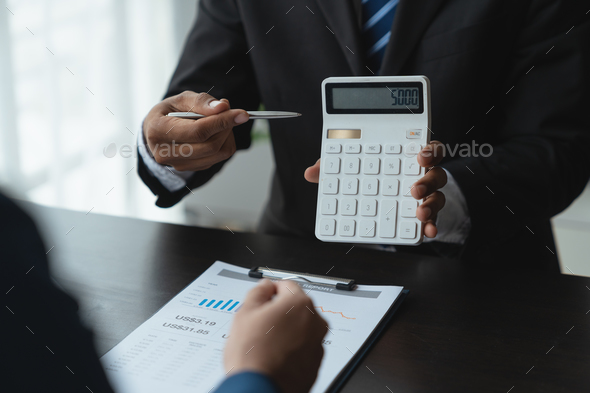 Team of business people working on desk using calculator calculate ...