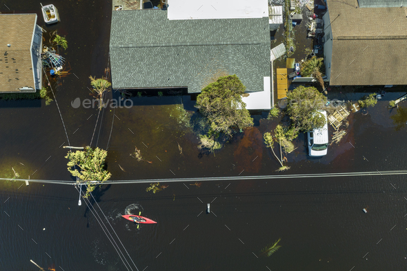 Aftermath of flooding natural disaster. Kayak boat floating on flooded ...
