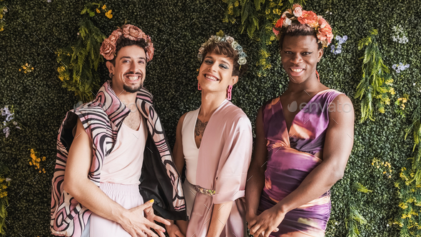 Trans men posing in colorful dresses and a crown of flowers Stock Photo ...