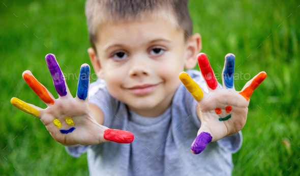 Children's hands in the colors of summer, a smile on the boy's palm ...