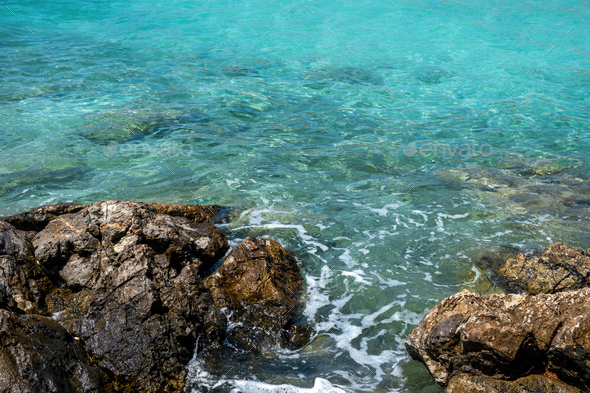 Foamy wave breaks on rock in sea water background. Greece Agistri ...