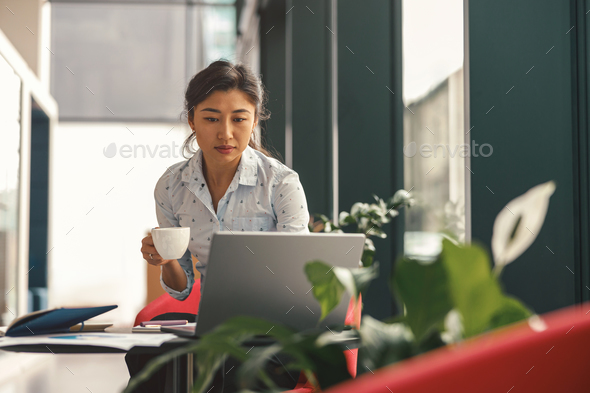 Focused stylish business woman working on laptop sitting the desk on ...