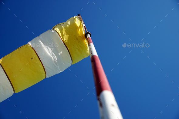 Low angle shot of a yellow and white windsock floating in the air ...